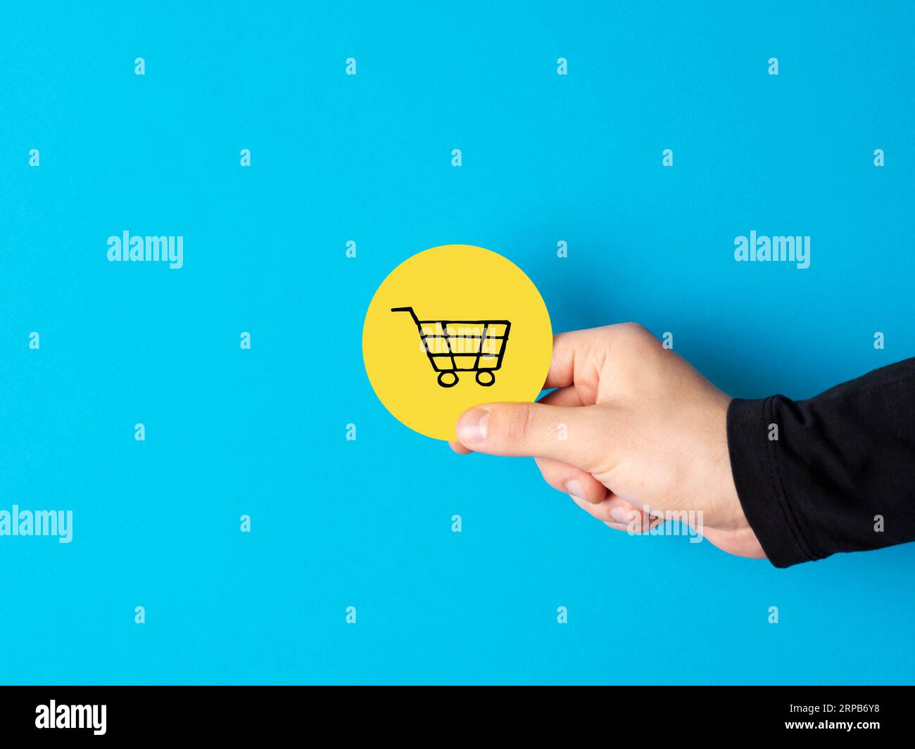 Shopping or add to basket concept. Male hand holding a yellow badge ...