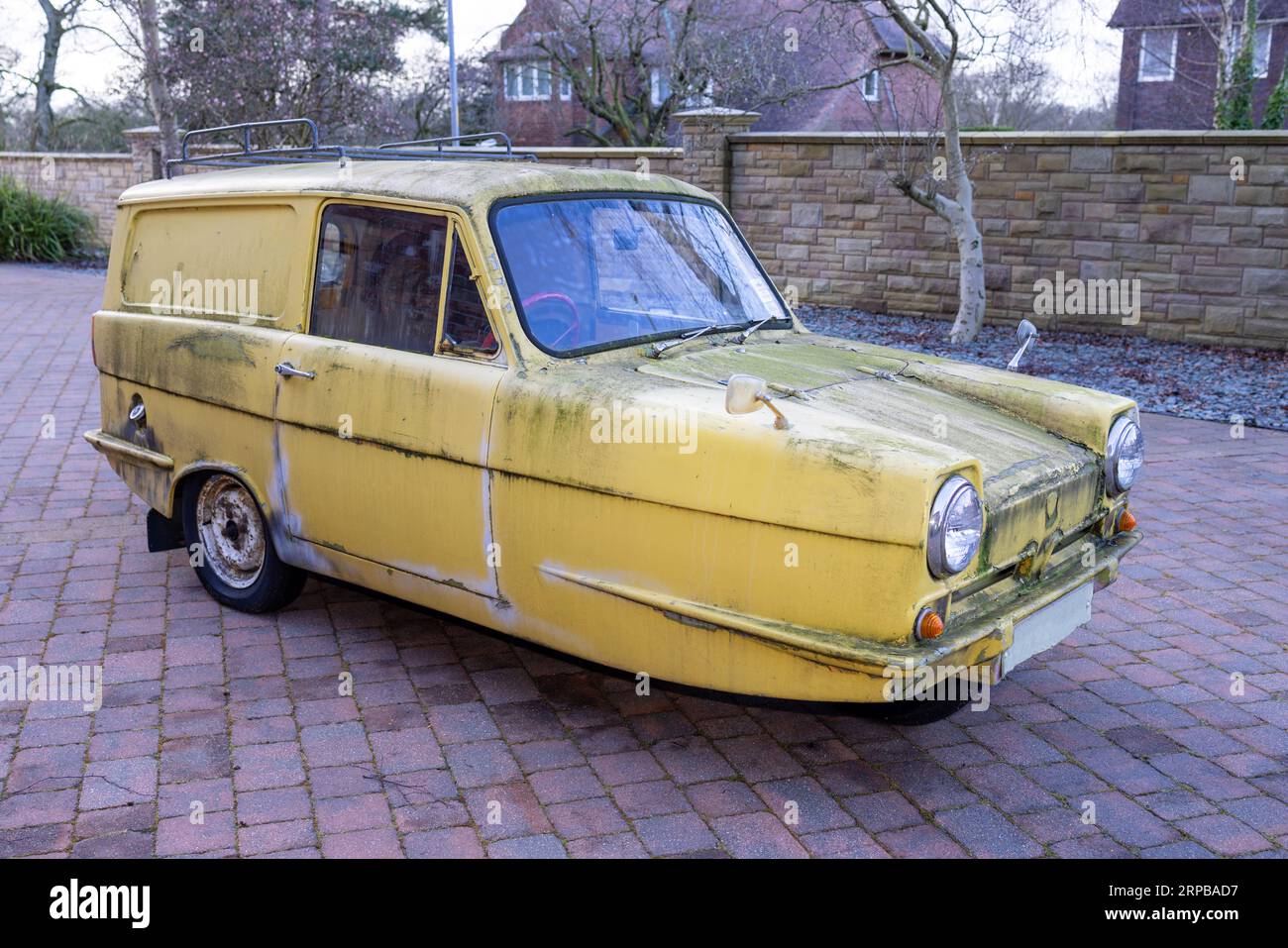 A classic historic Reliant Robin 3 wheel van the colour yellow used for ...