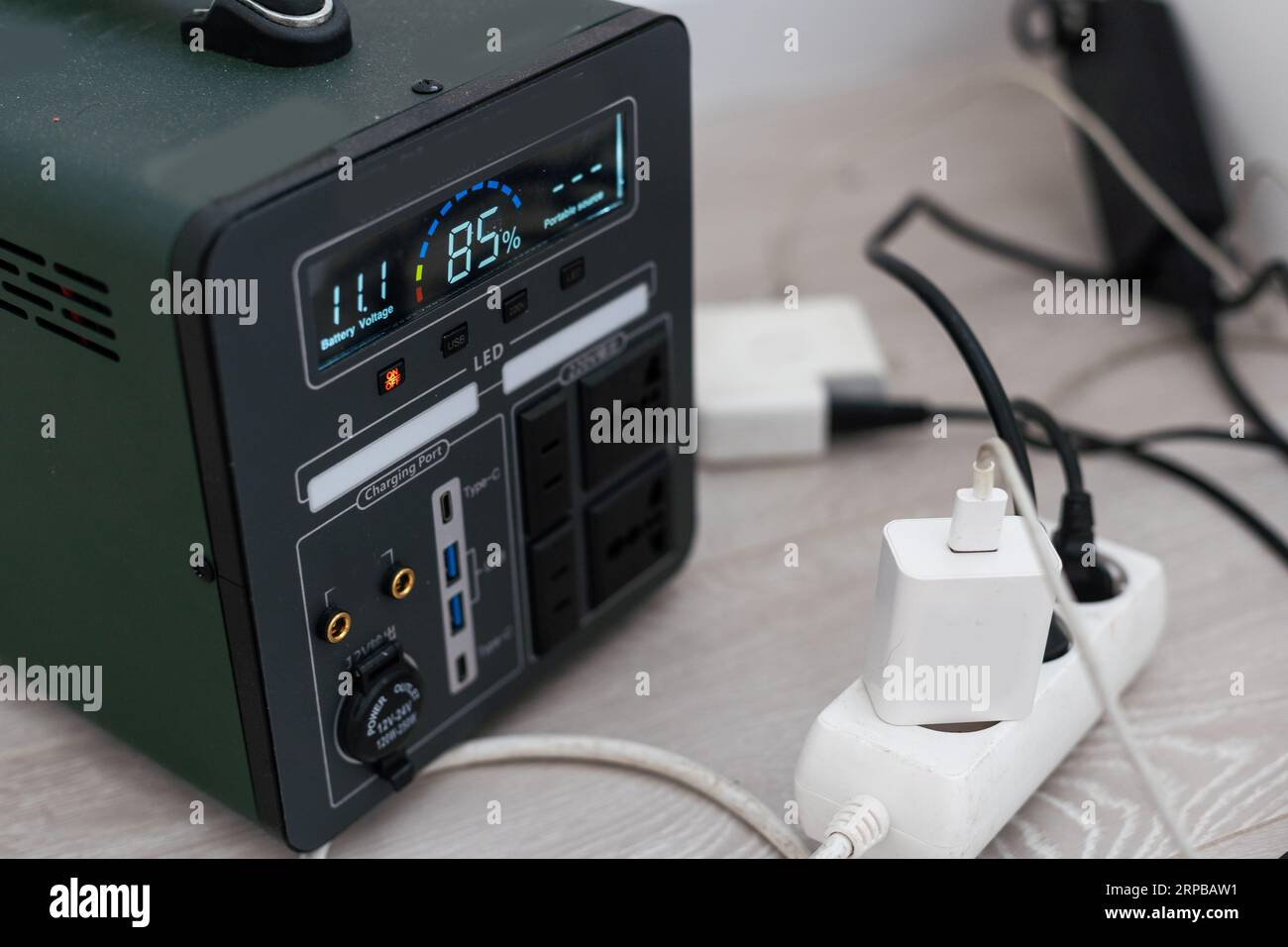 Portable power station charging gadgets near wall Stock Photo - Alamy