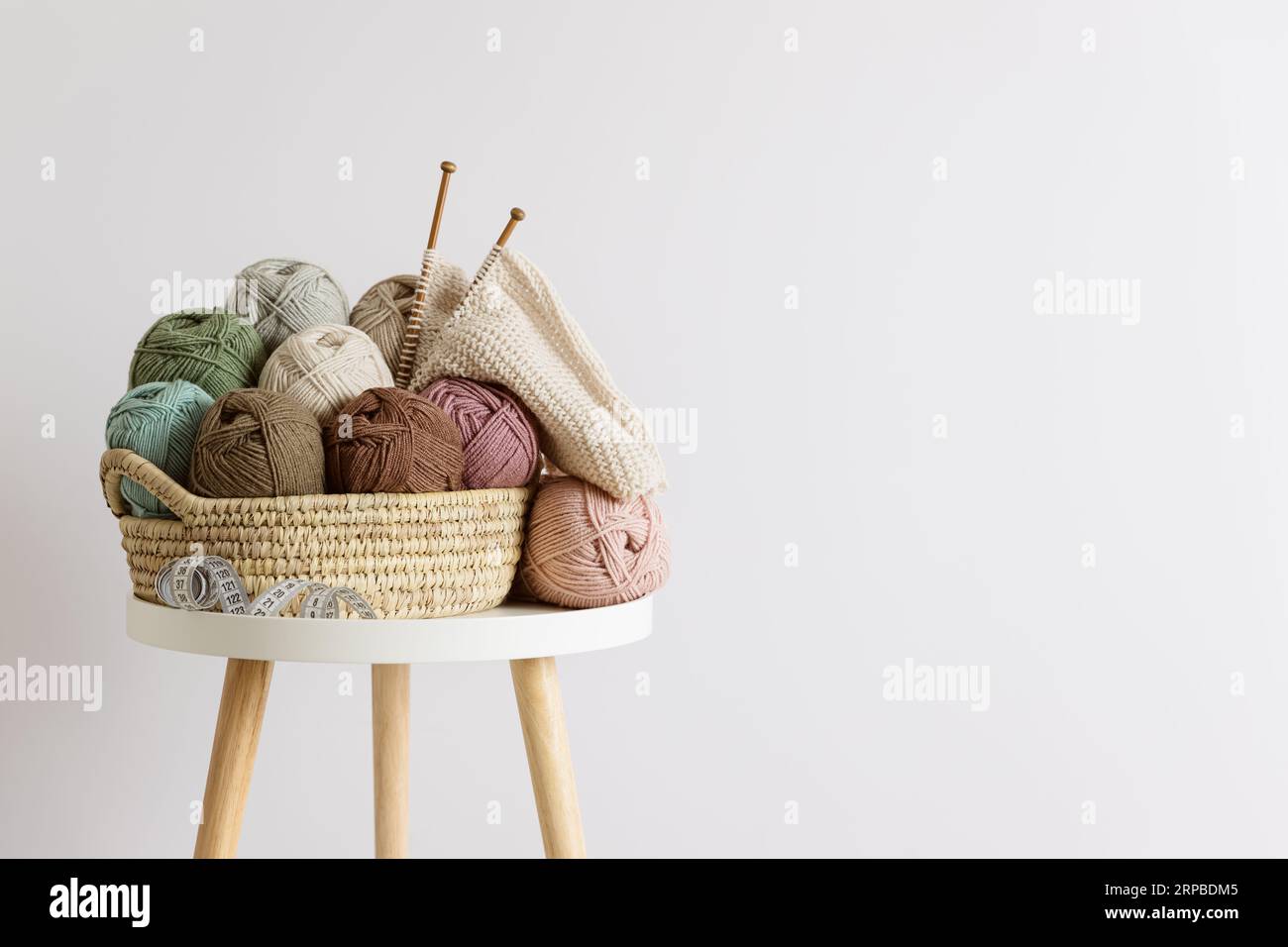 Natural wool in balls of various pastel colors in a wicker basket on ...