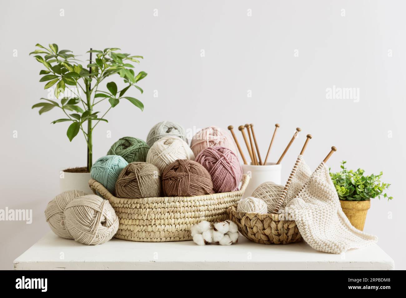 Natural wool in balls of various pastel colors in a wicker basket on ...