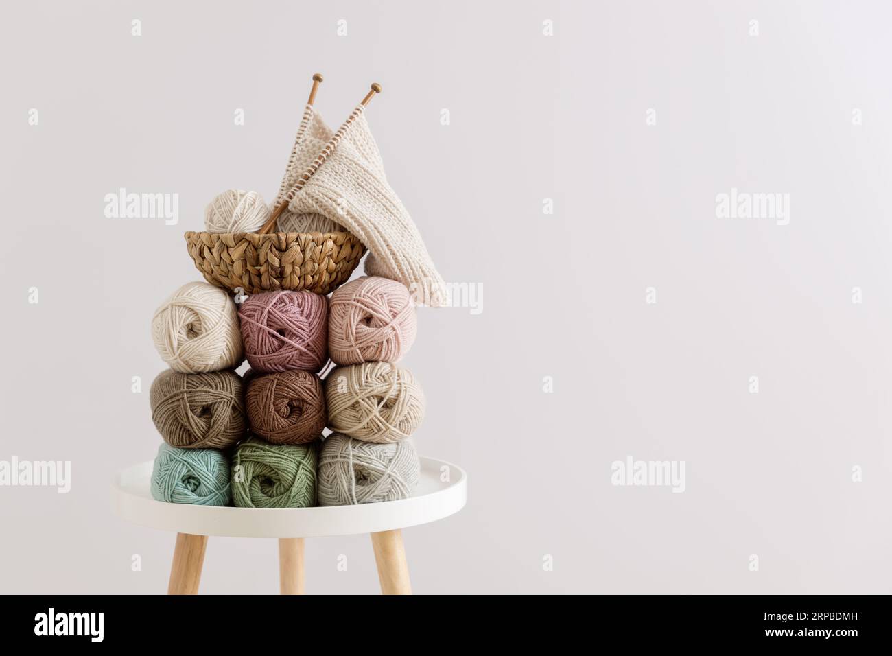 Natural wool in balls of various pastel colors on table. Copy space ...