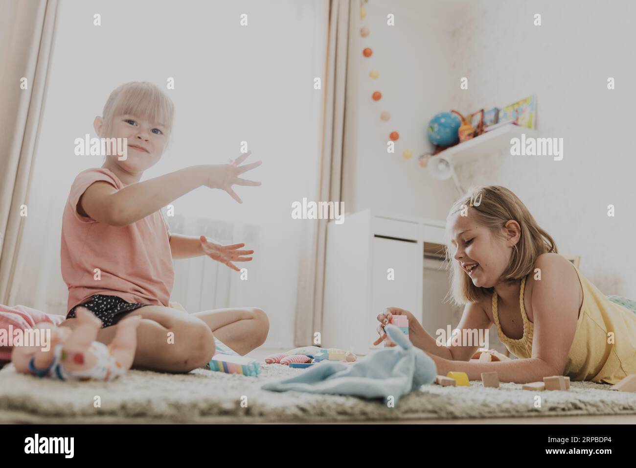 Children playing with colorful toys. Kids sitting on carpet at home ...