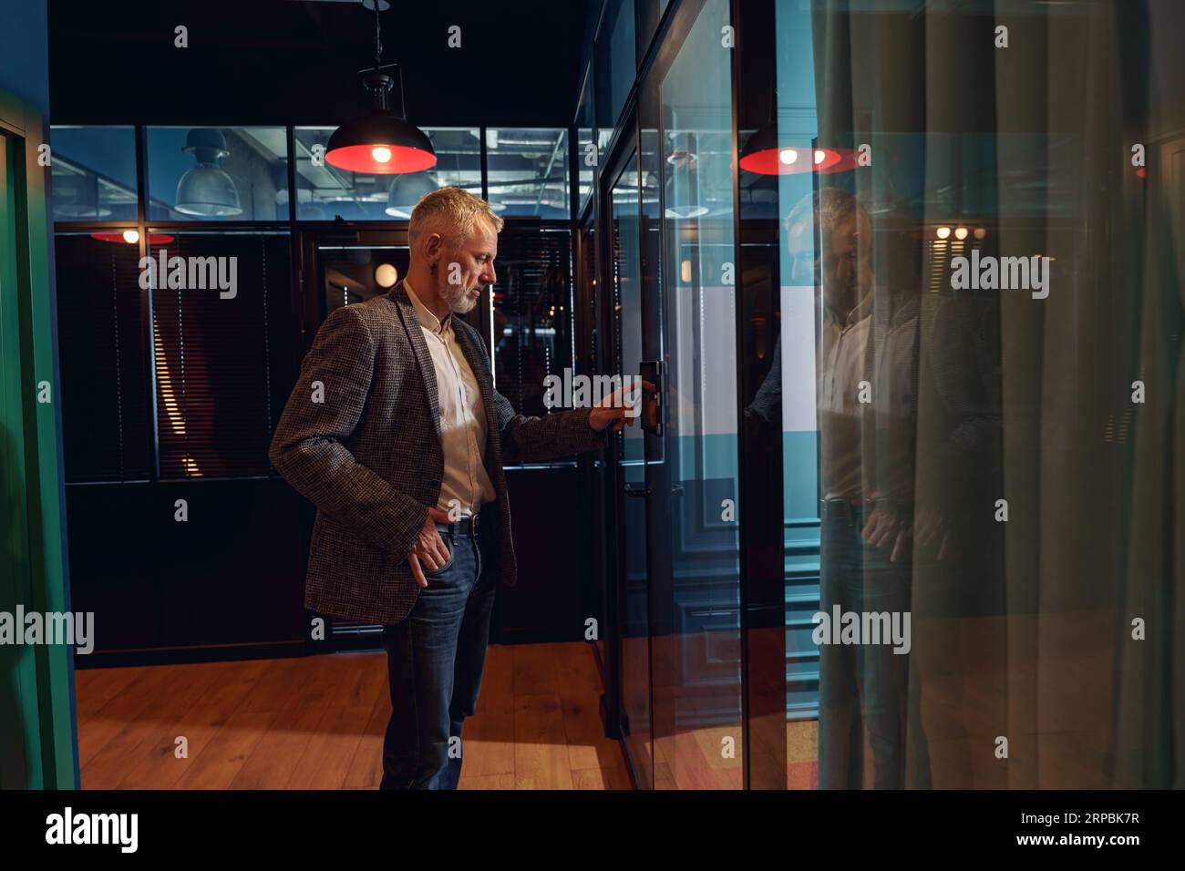 Businessman enters password lock code on alarm panel in office door for ...