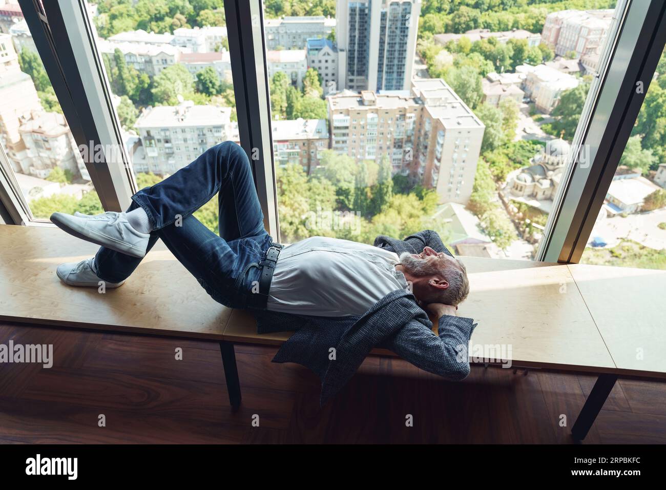 Top view of tired senior businessman resting on wooden desk in office ...
