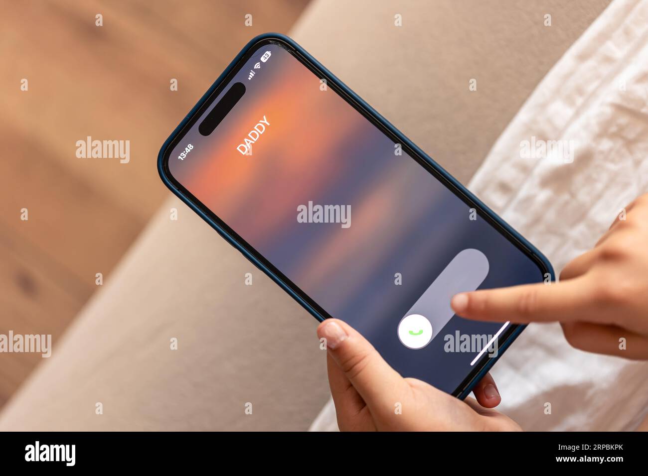 Close up of child hands holding phone with Dad's incoming call on ...