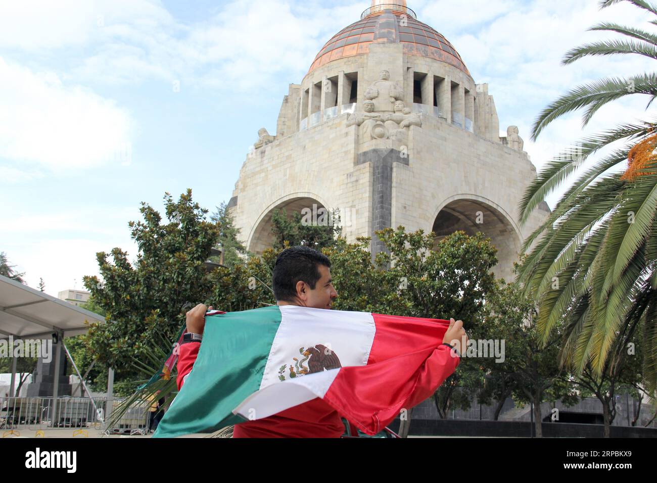 Dark-haired latino adult man shows the flag of mexico proud of his ...