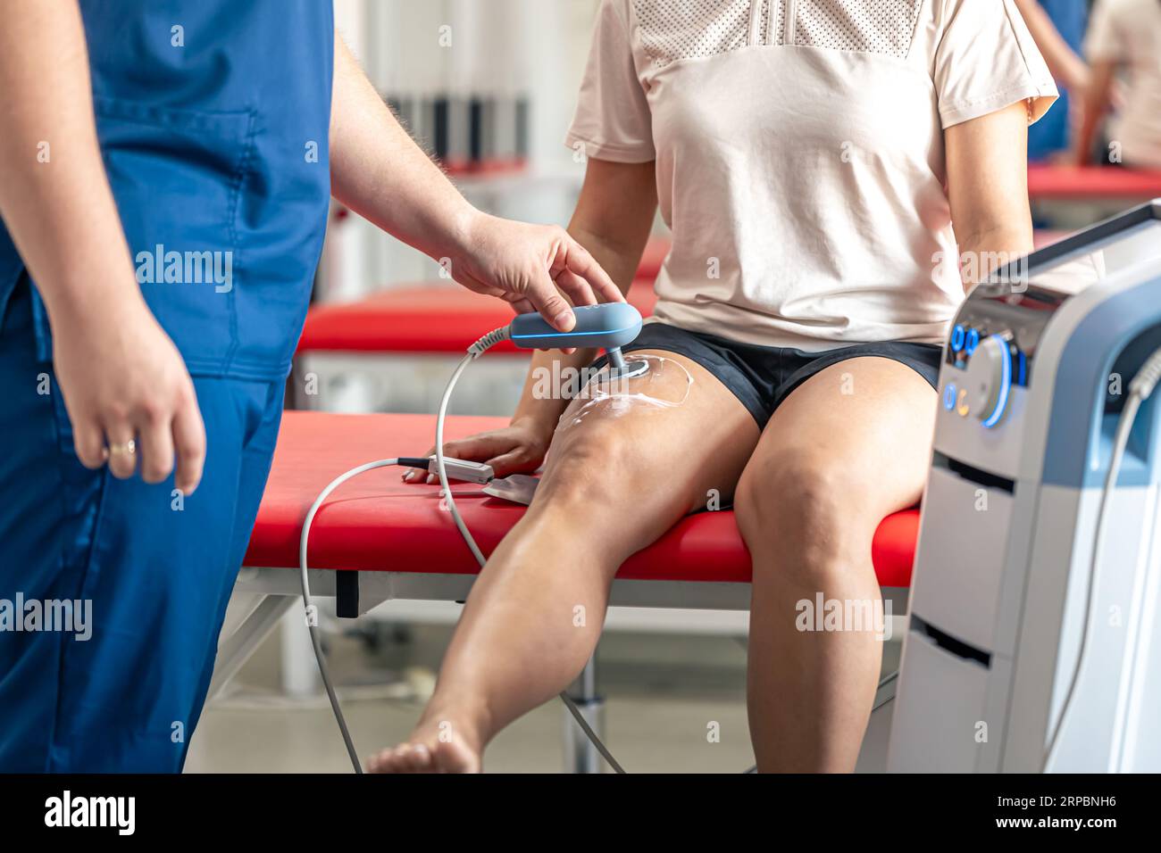 Doctor using machine to treat the knee joints of a patient Stock Photo ...