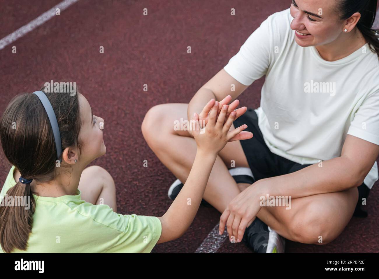 Strong mother and daughter giving high five at the stadium Stock Photo ...
