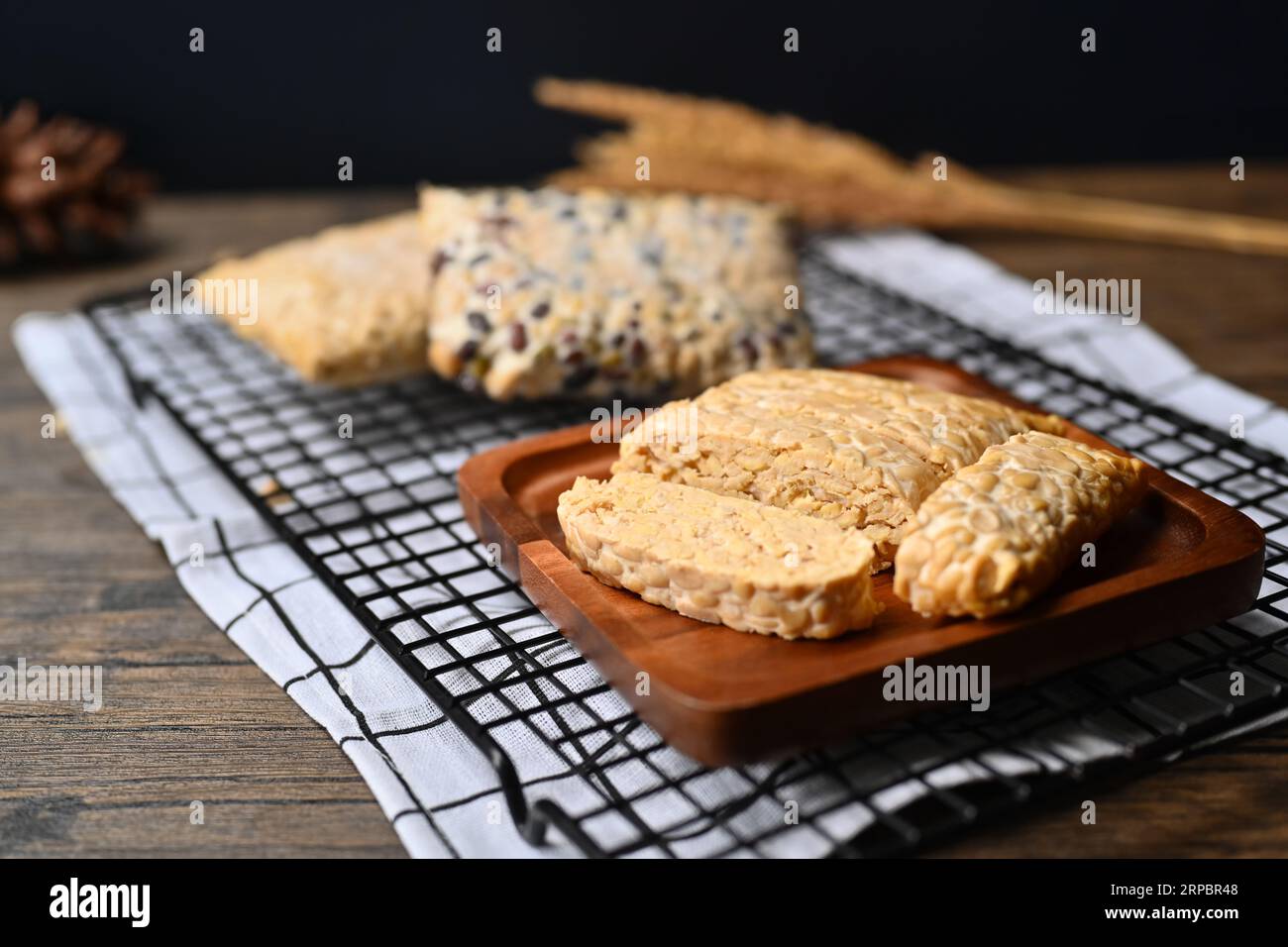 Slices of tempe on the wooden kitchen tabletop. Food from fermented ...