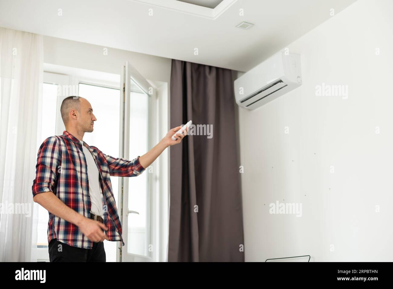 Full length young man wearing glasses holding using air conditioner ...