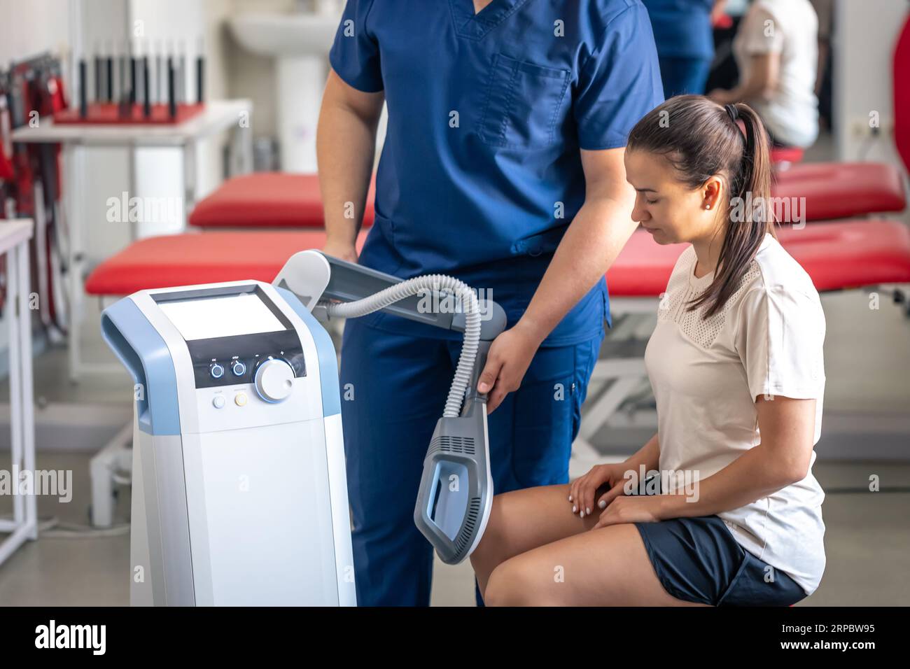Doctor using machine to treat the knee joints of a patient Stock Photo ...