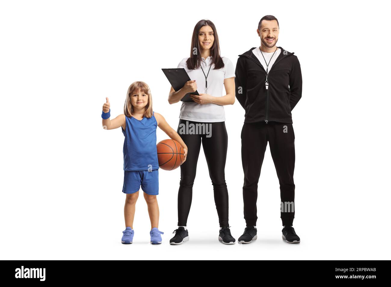 Male and female coaches posing with a girl holding a basketball and ...