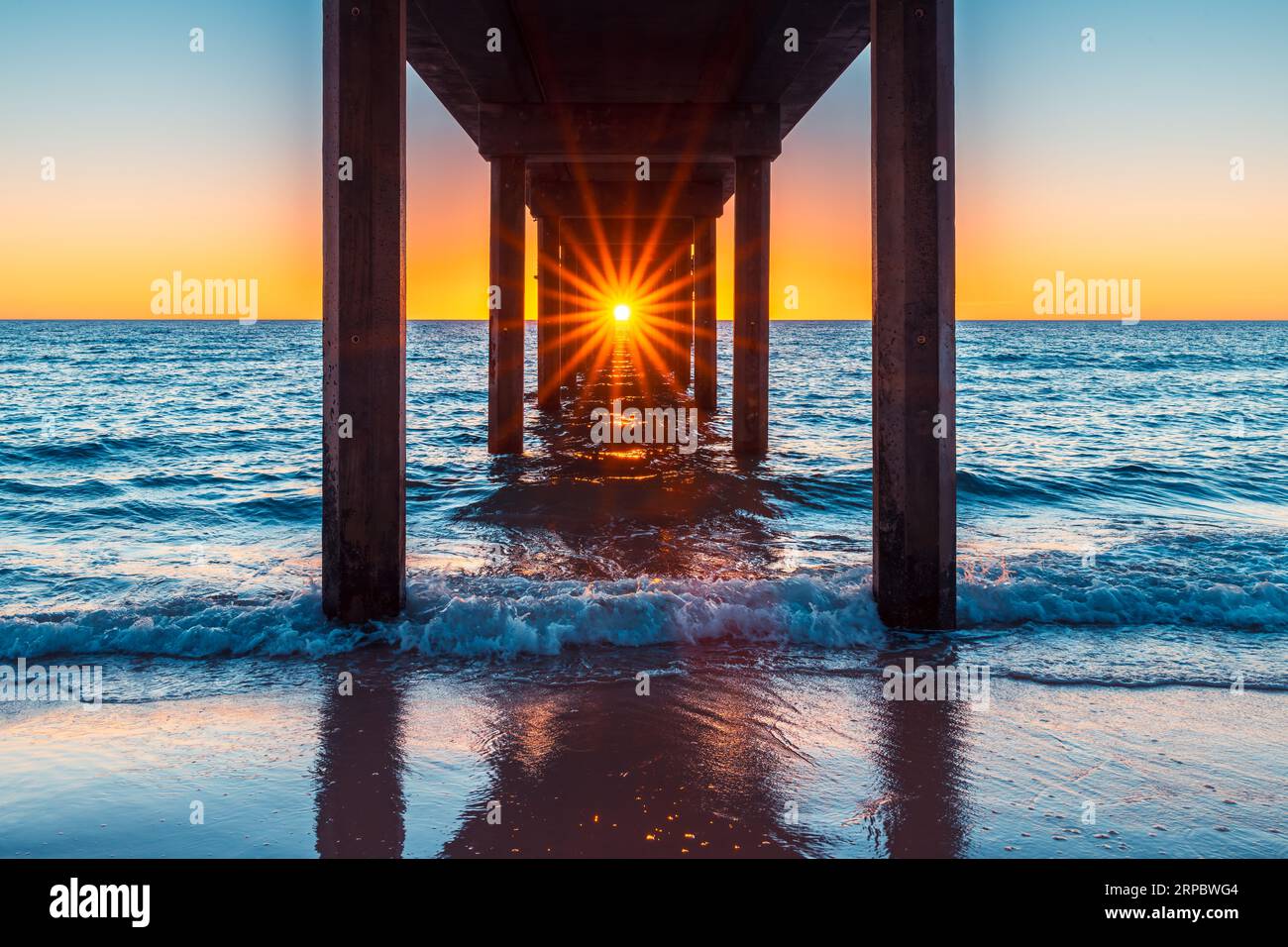 Sun shining through Brighton Jetty pylons while viewed from the beach ...