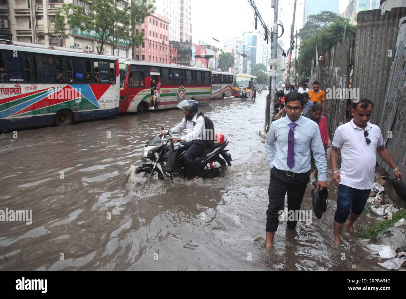 Dhaka, Bangladesh. on August 09, 2023.. Bangladeshi people cross a flooded street in Dhaka ...