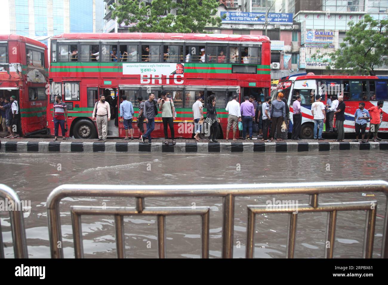 Dhaka, Bangladesh. on August 09, 2023.. Bangladeshi people cross a flooded street in Dhaka ...