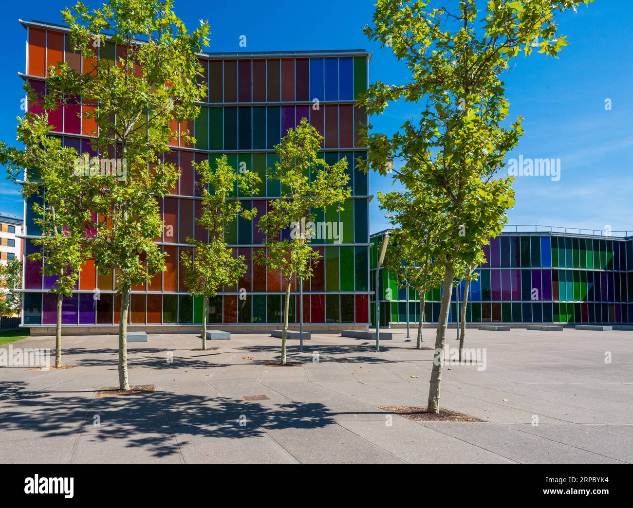 View of a building with colorful windows and trees in the front Stock ...
