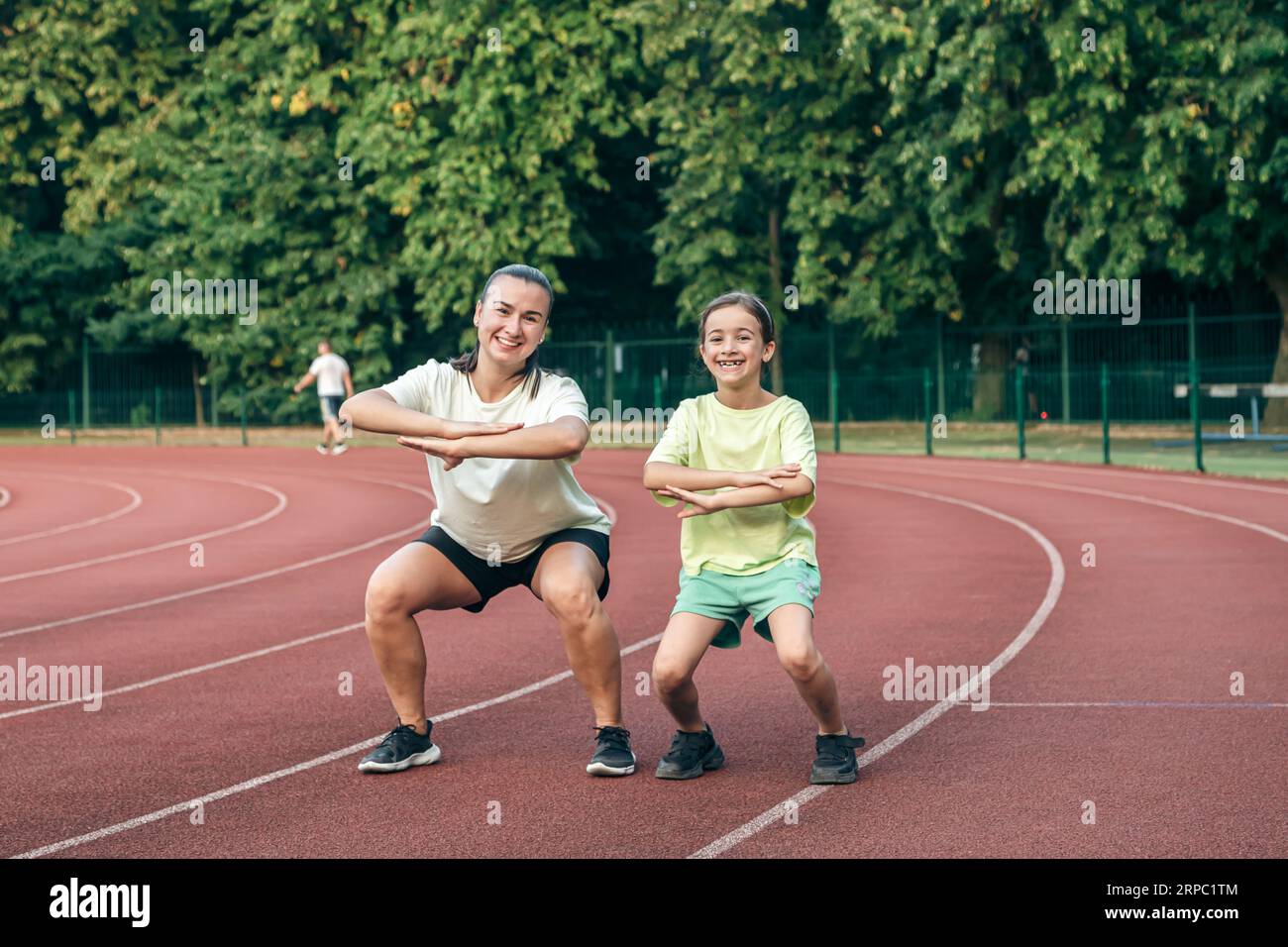 Mother and little daughter are doing exercise in the stadium Stock ...