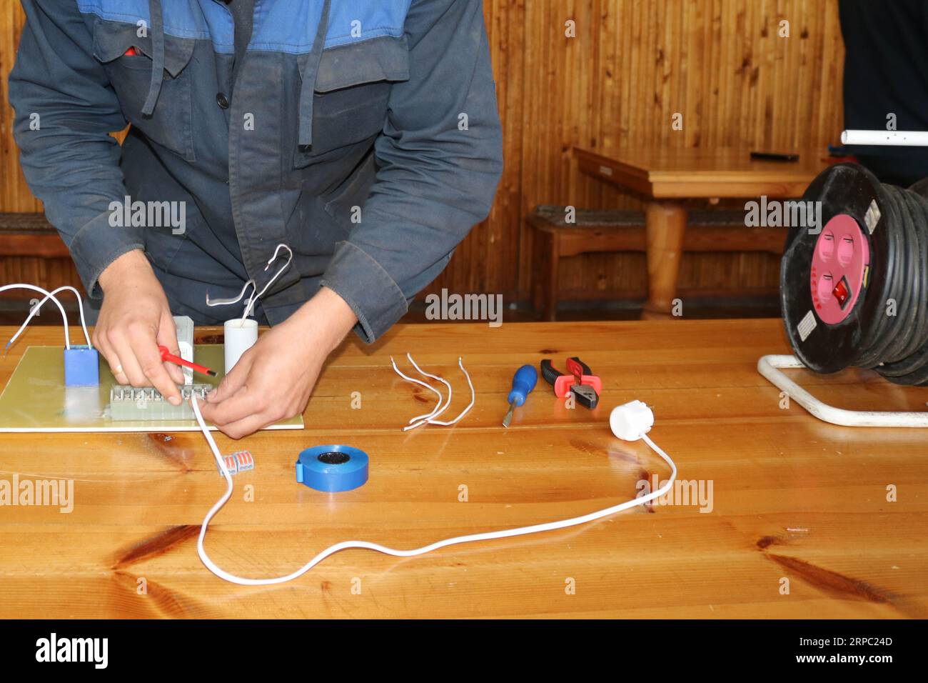 A man working electrician works, collects the electric circuit of a ...