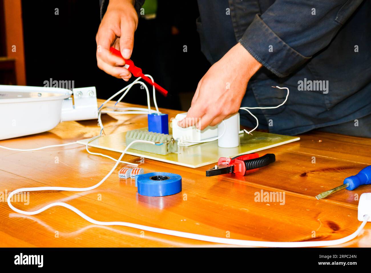 A man working electrician works, collects the electric circuit of a ...