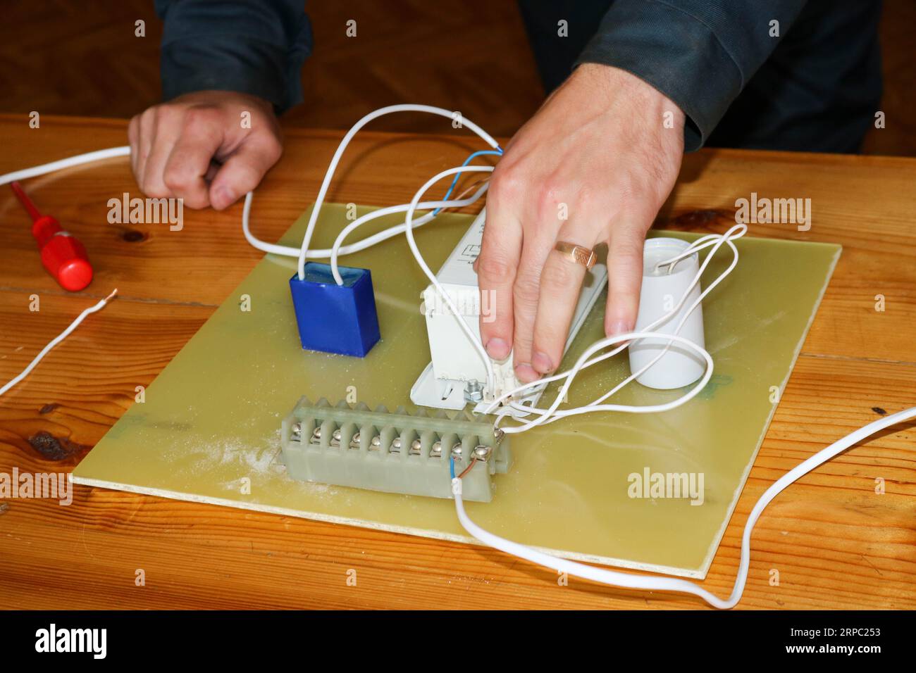 A man working electrician works, collects the electric circuit of a ...