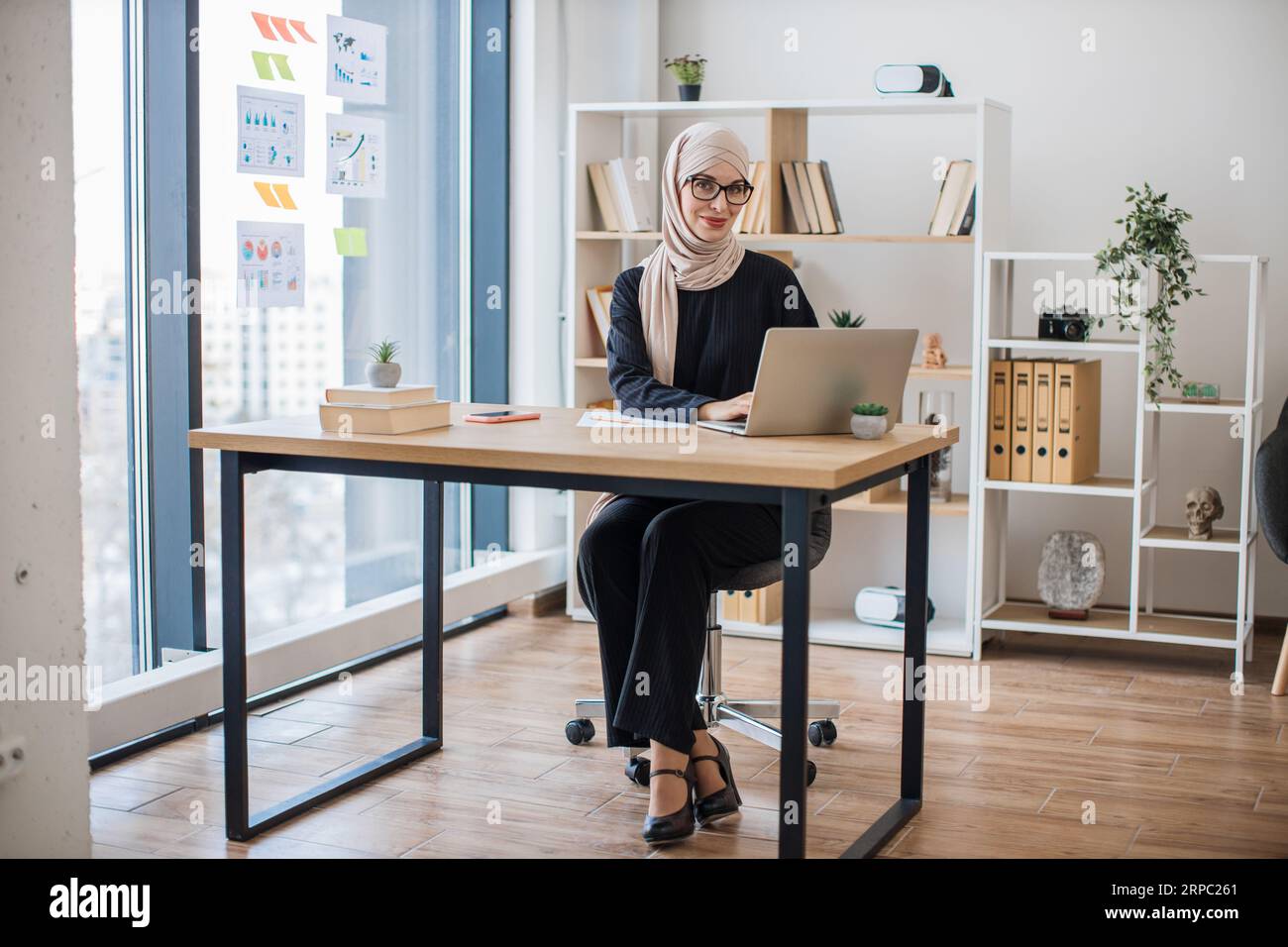 Woman posing behind computer on working day in office Stock Photo - Alamy