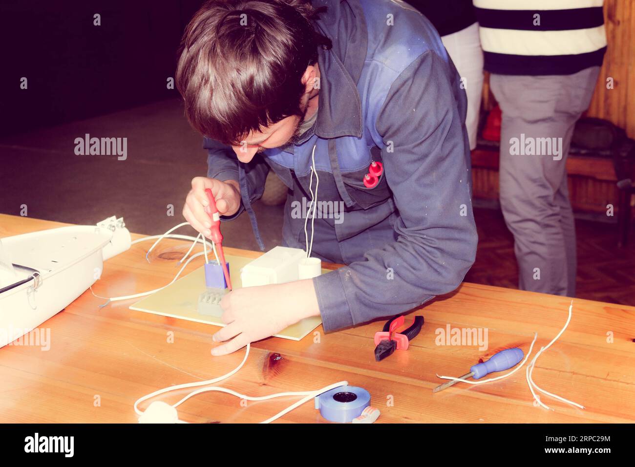 A man working electrician works, collects the electric circuit of a ...