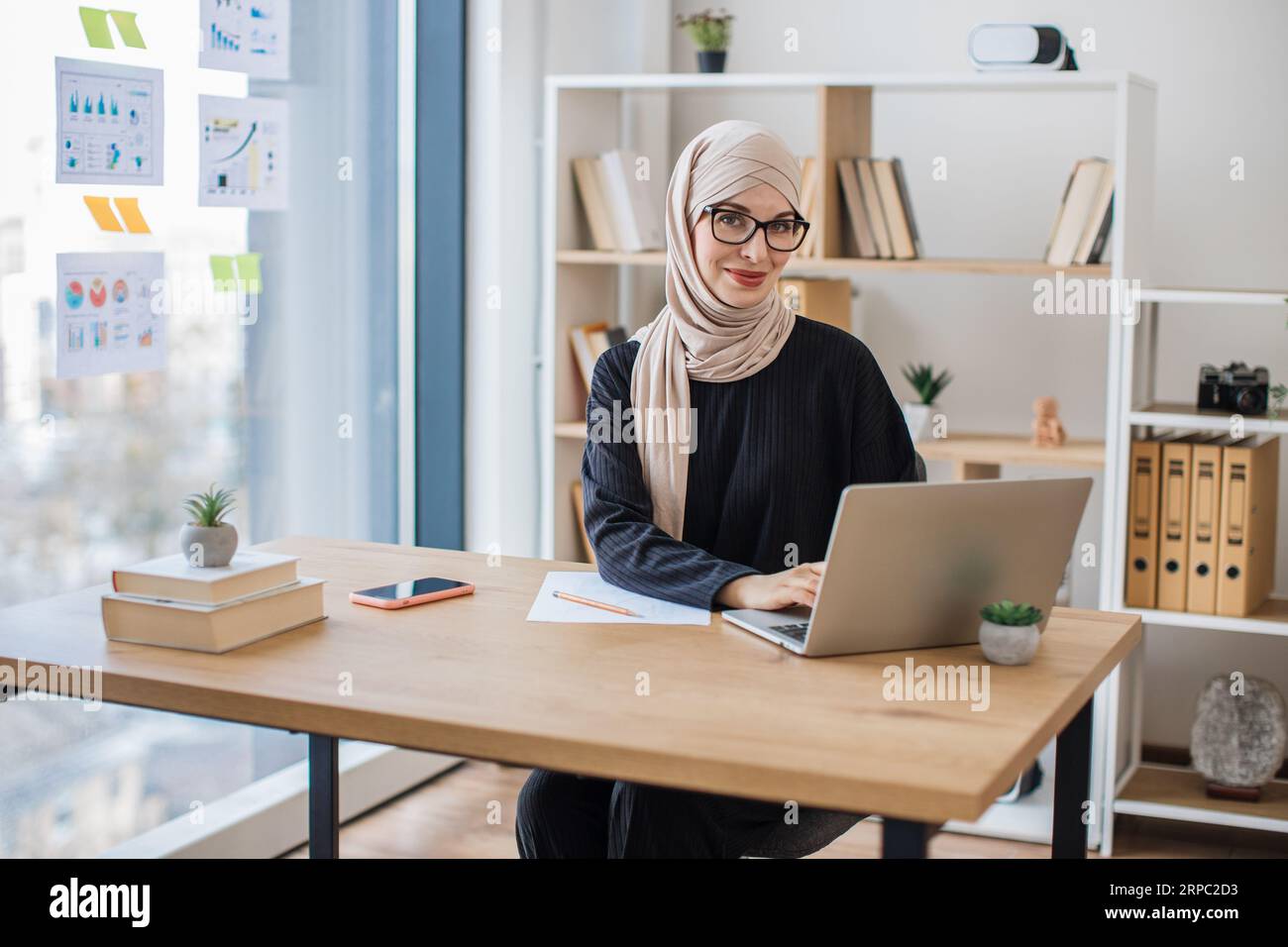 Woman posing behind computer on working day in office Stock Photo - Alamy