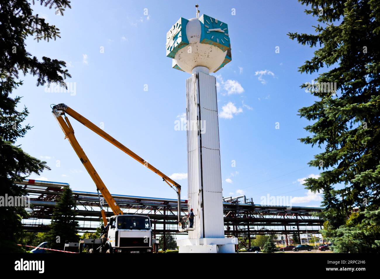 Repair of the tower clock. Workers on the crane repair clock-column ...