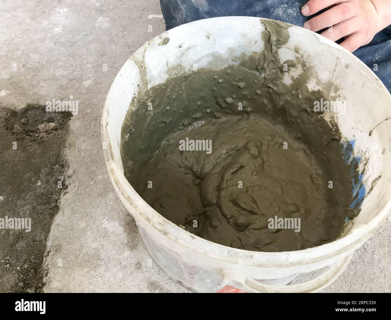 Large white plastic construction bucket with spatula and plaster, tiled ...