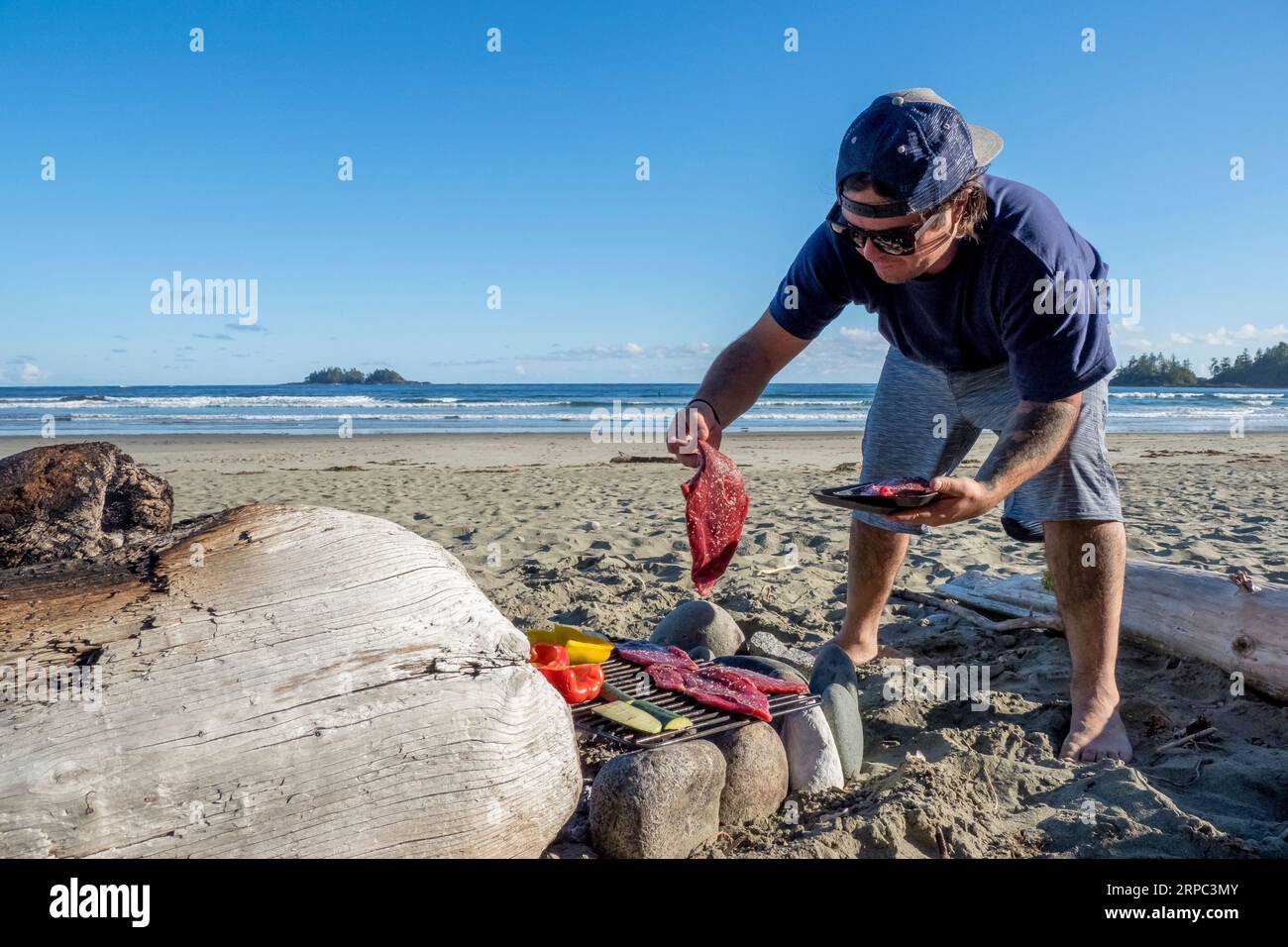 Man cooking food over campfire on beach,â€ Tofino, British Columbia ...