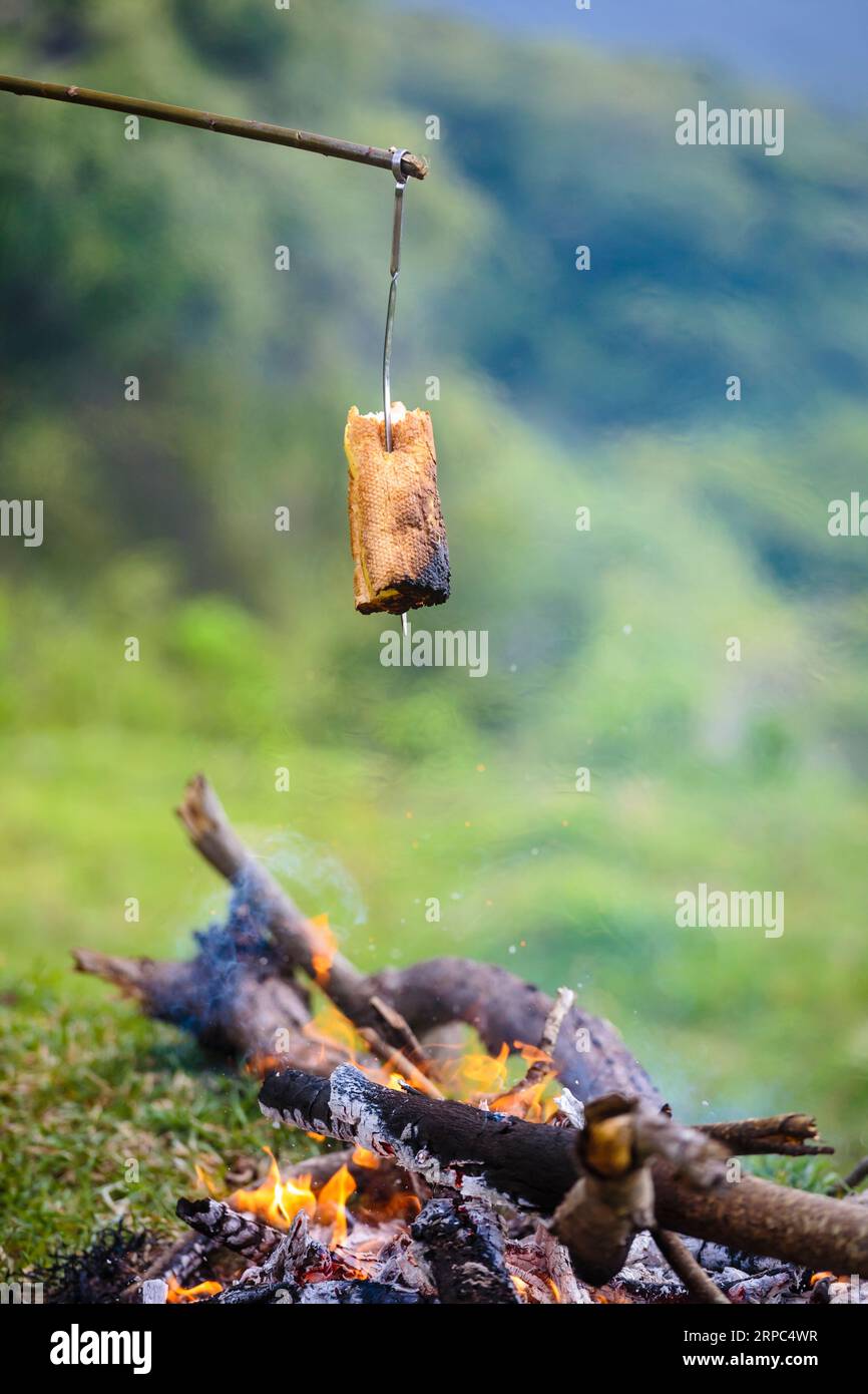 Bread toasting over campfire, Nusa Penida, Bali, Indonesia Stock Photo ...