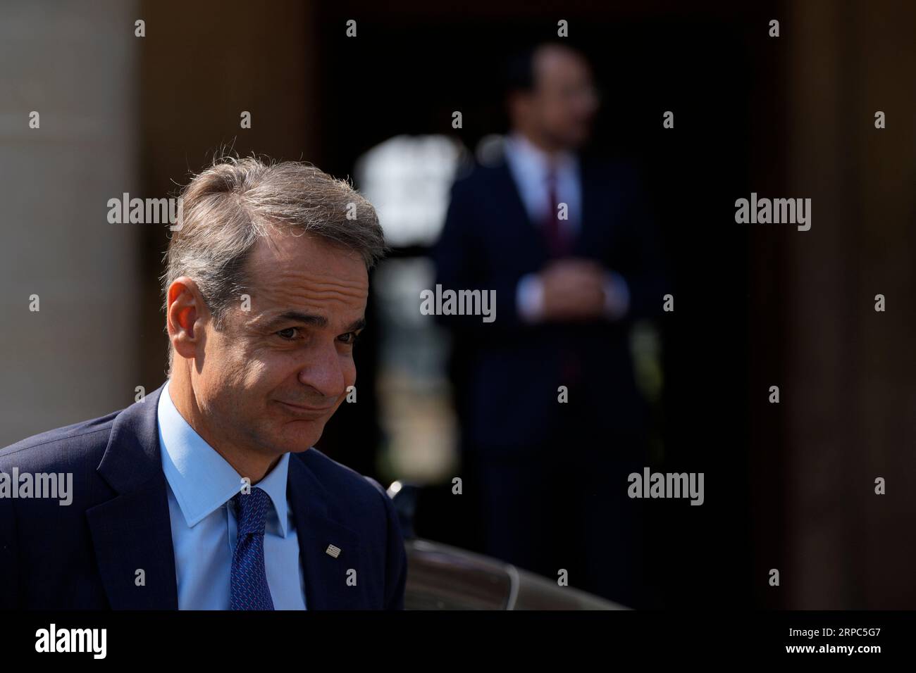 Cypriot President Nikos Christodoulides, in the background, waiting as ...