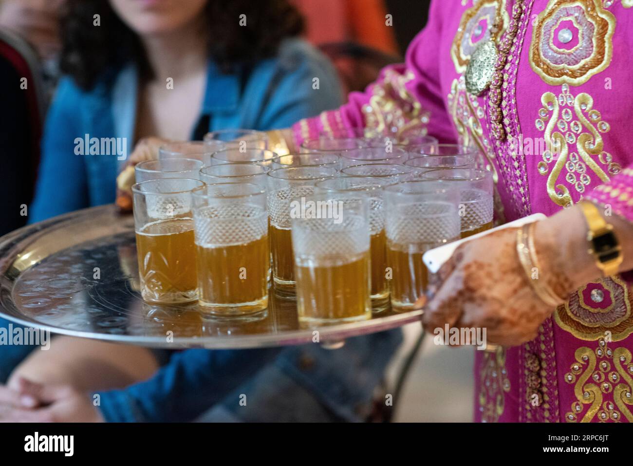 Moroccan woman carrying a tray with tea for the guests of a party Stock ...