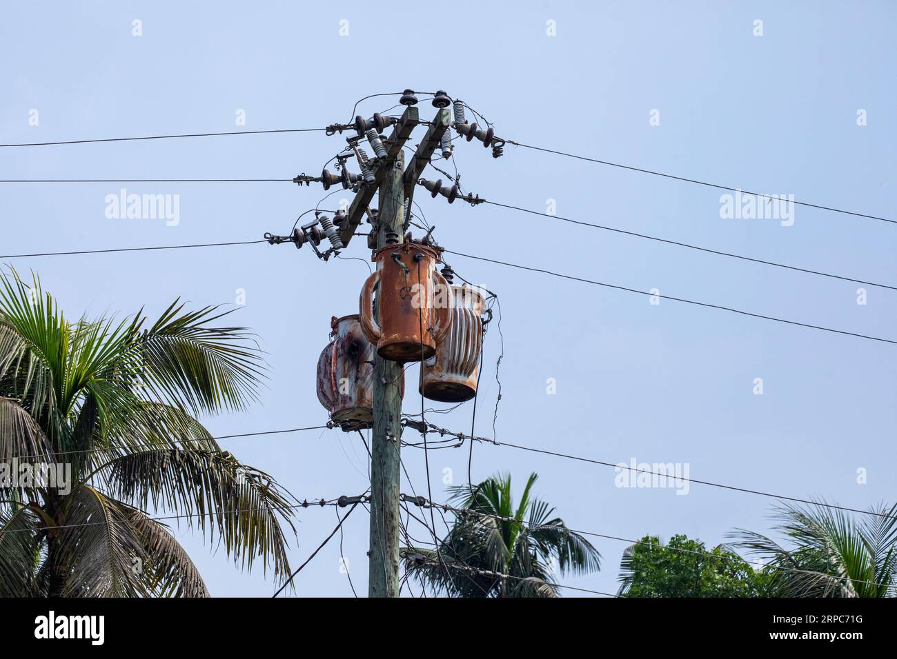 Electric transformers and transmission wires attached to a wooden power pole. Barisal ...