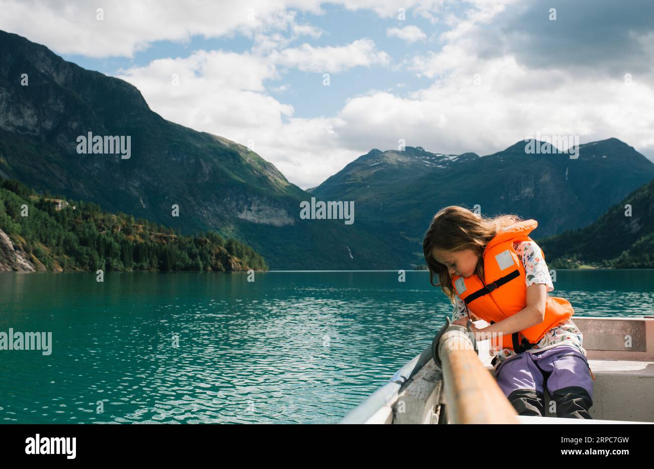 girl sat in a rowing boat testing the water in a Norwegian fjord Stock ...
