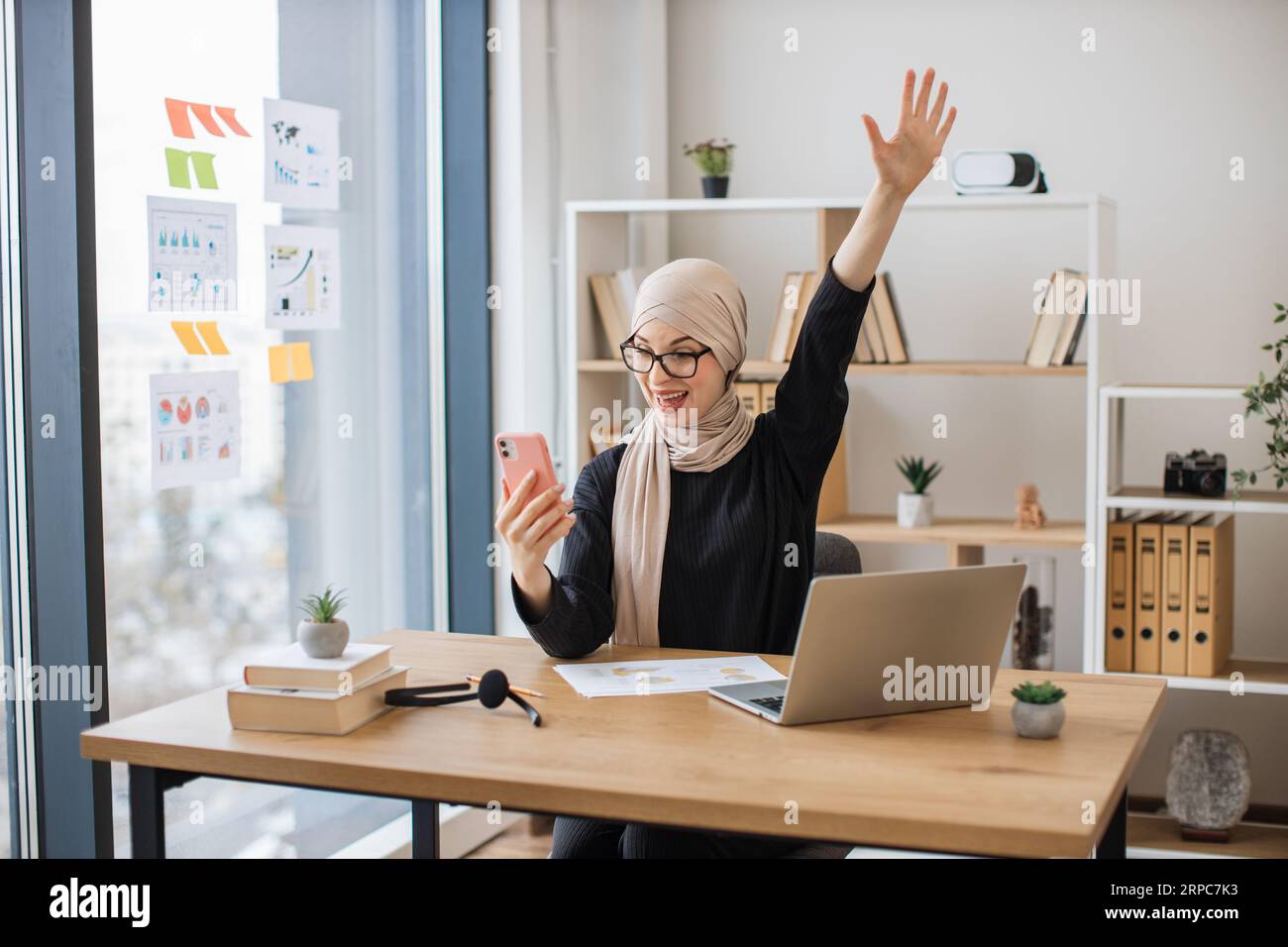 Employee with phone raising arm with winner's sign in office Stock ...