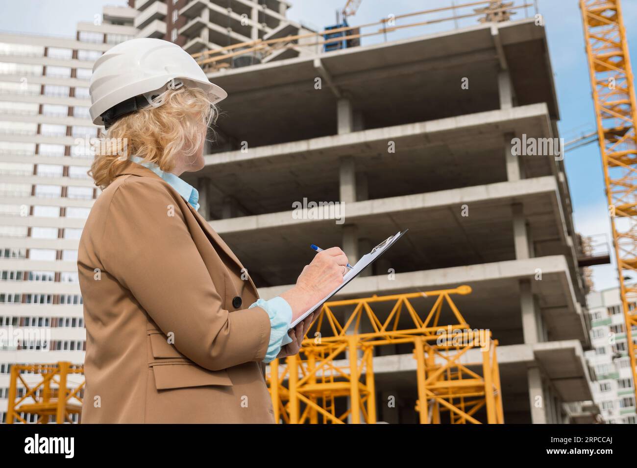 Entrepreneur makes notes on clipboard of building processes Stock Photo ...