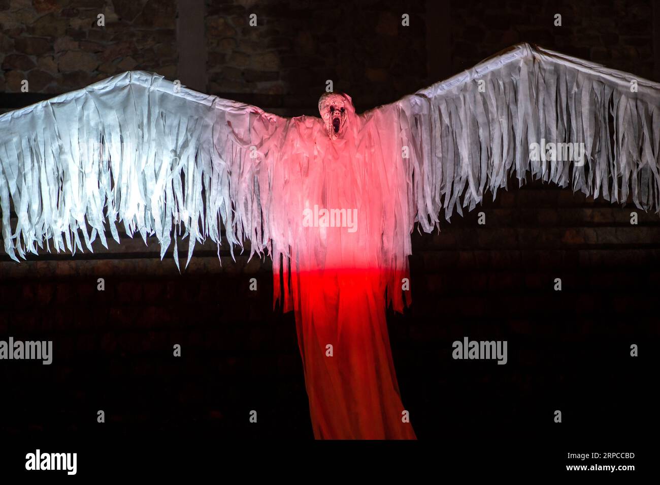 A spooky Halloween decoration stands in a wooded area creating a ...