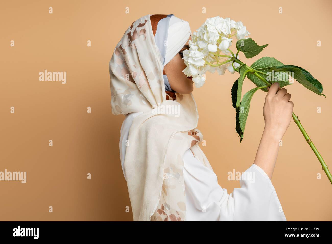 side view of modest muslim woman in headscarf and blouse obscuring face ...
