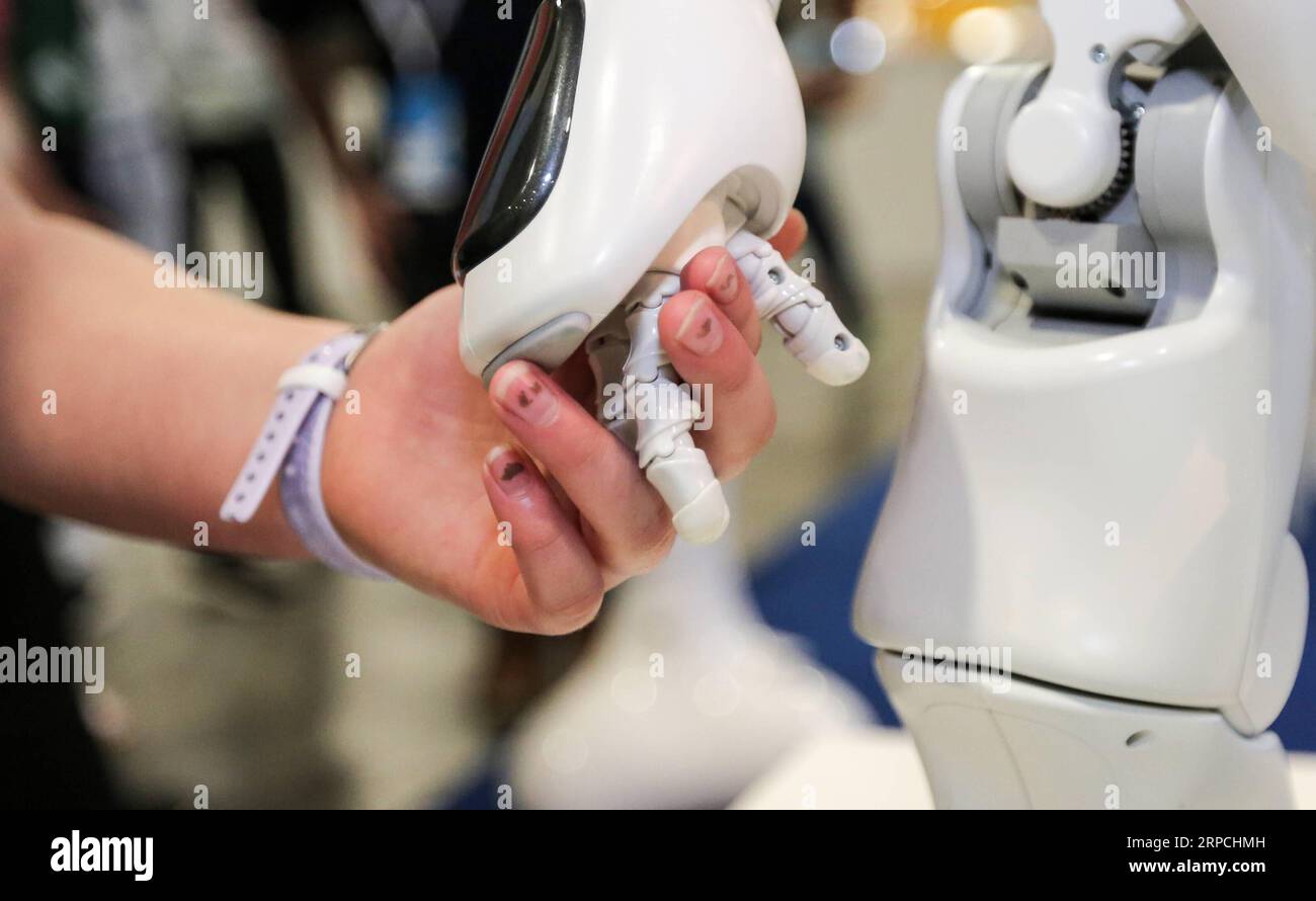 (190705) -- SYDNEY, July 5, 2019 -- A kid holds the hand of a robot at ...