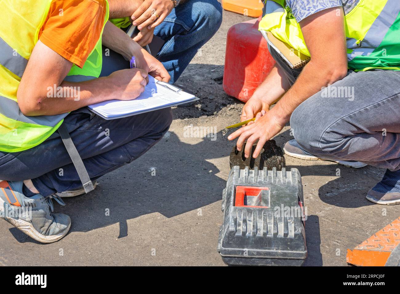Road maintenance engineers measure the core of the asphalt pavement ...