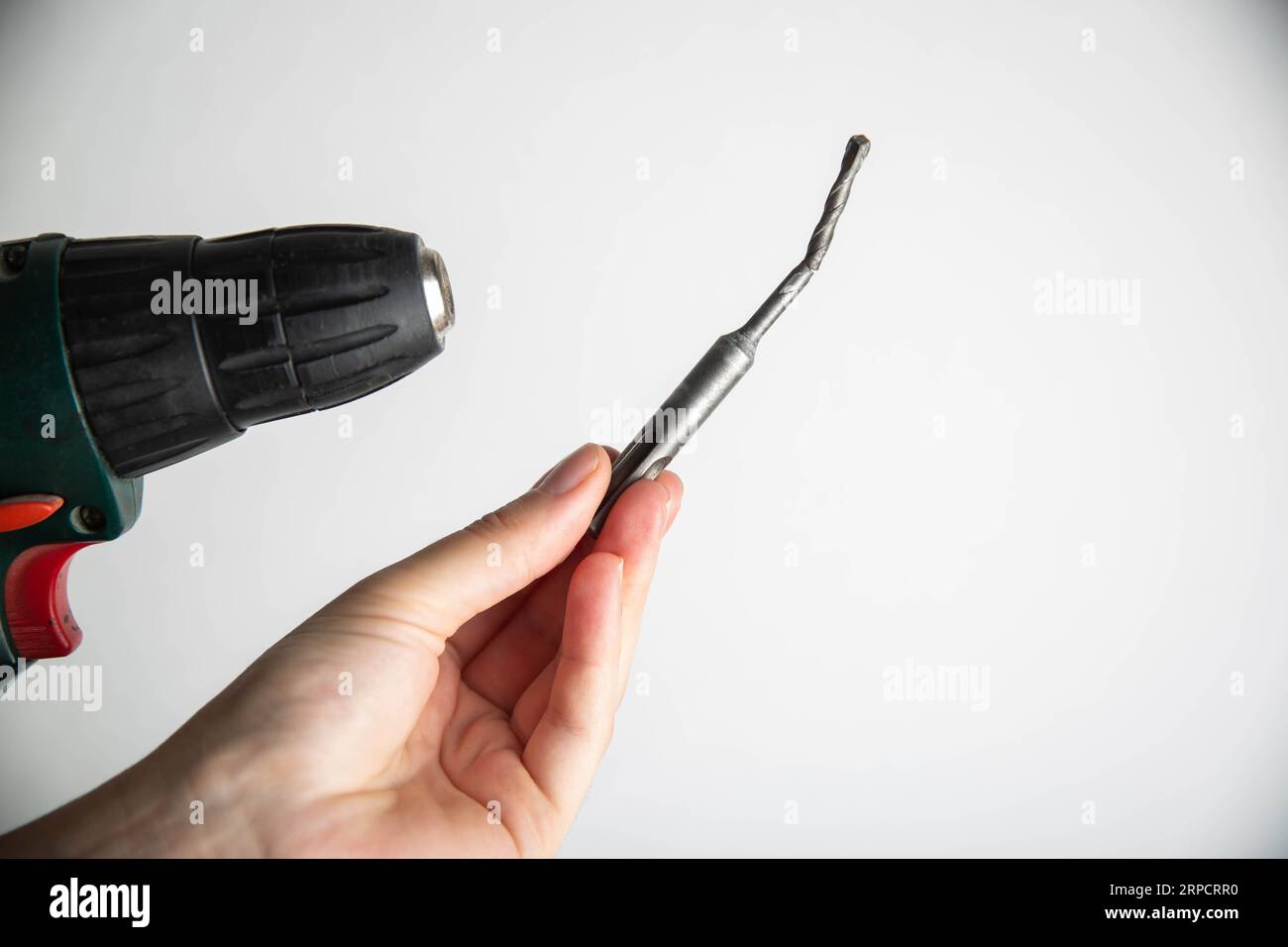 Poor quality broken metal drill on a white background Stock Photo - Alamy