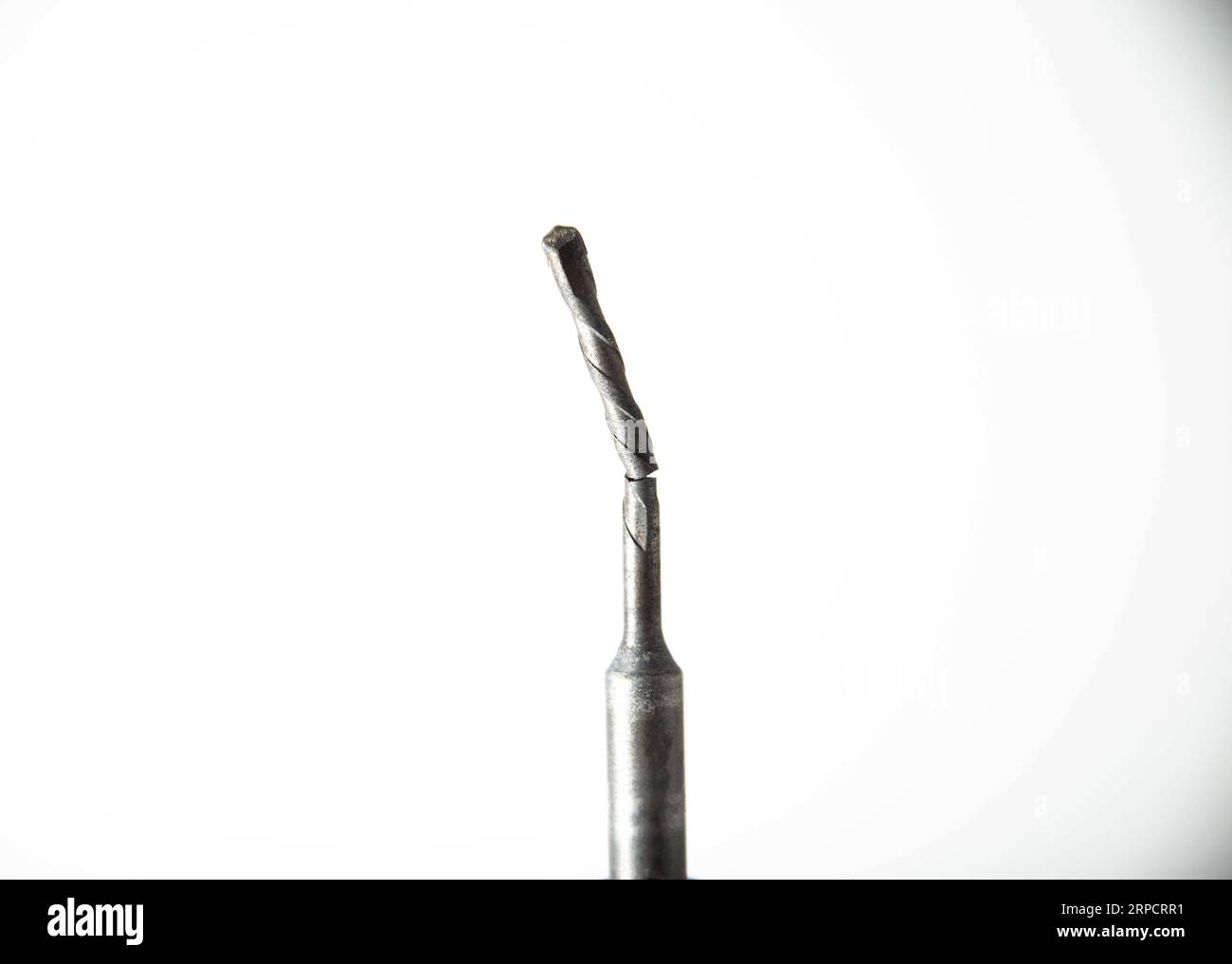 Poor quality broken metal drill on a white background Stock Photo - Alamy
