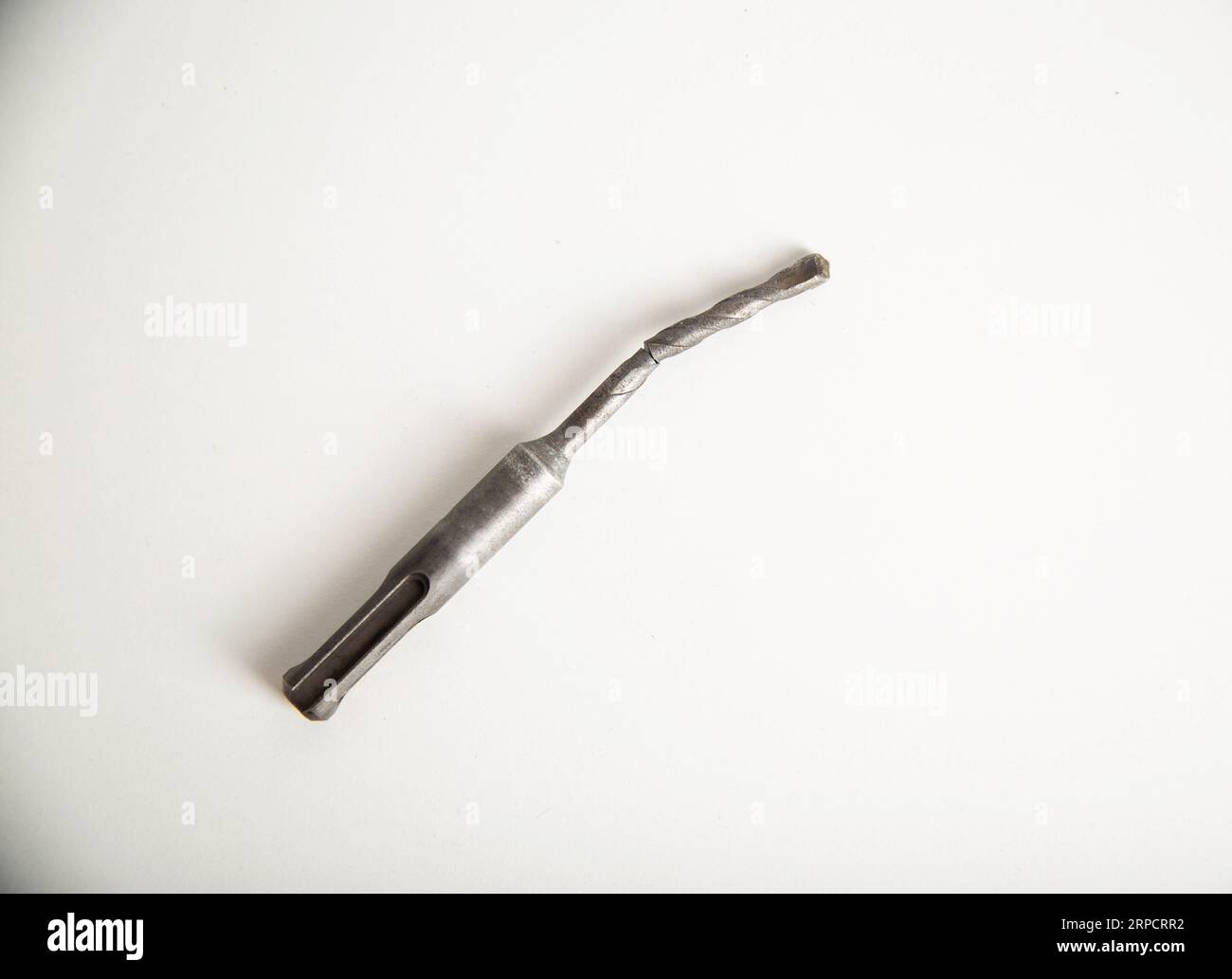 Poor quality broken metal drill on a white background Stock Photo - Alamy