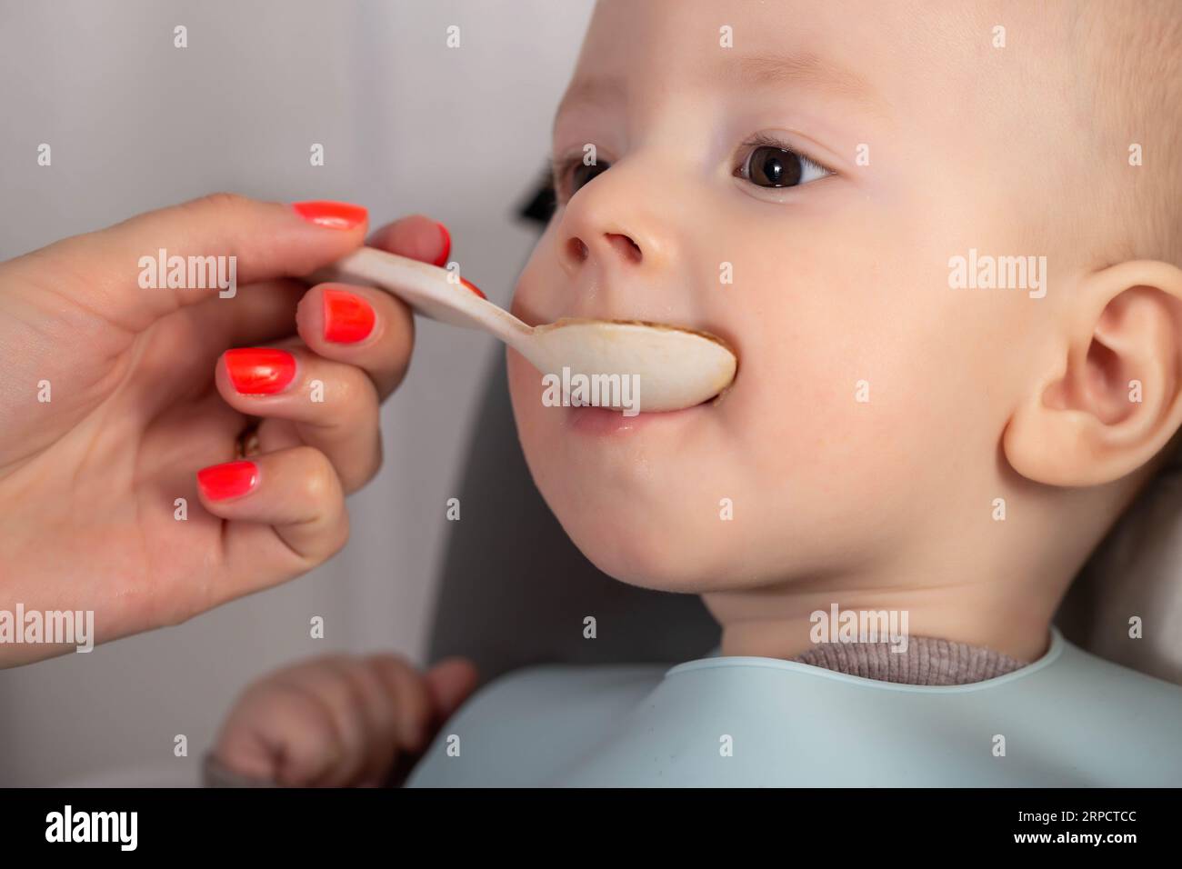 Feeding porridge and puree of a small child from a spoon. First meal ...