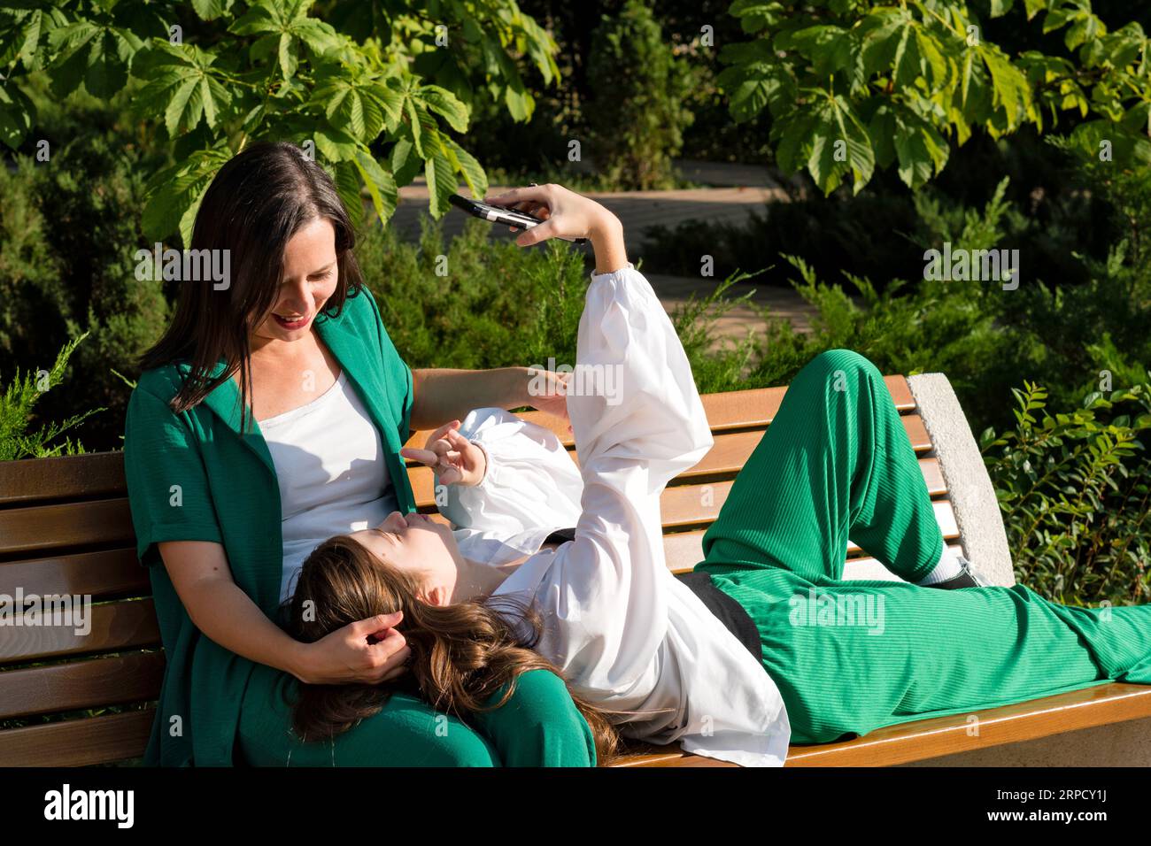 Mom and teenage daughter during walk in park. Teenager girl lies on her ...