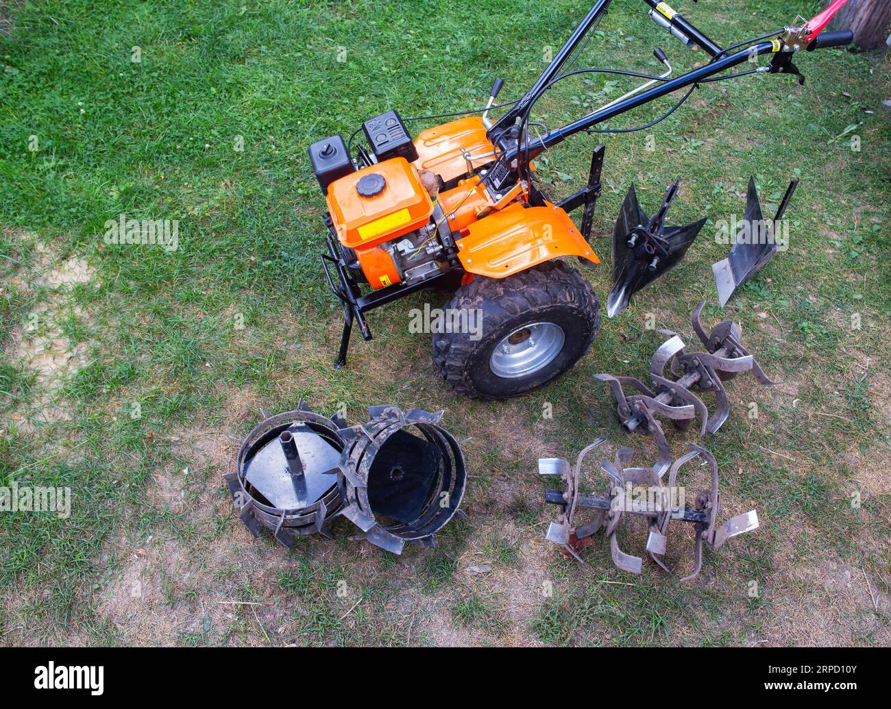 Agricultural walk-behind tractor with a set of attachments, hiller ...