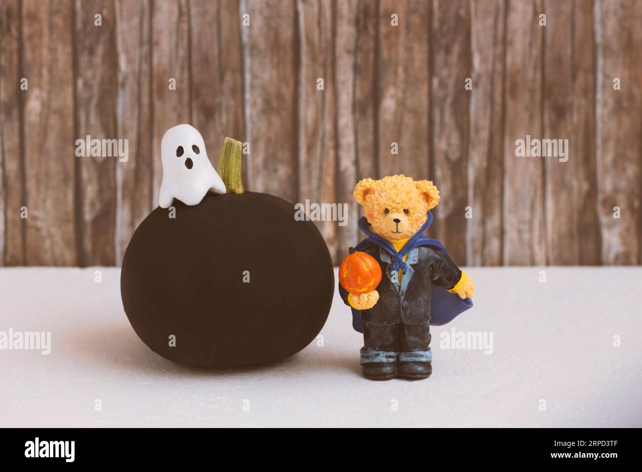 Teddy bear figure holding on scary halloween pumpkin and black pumpkin ...