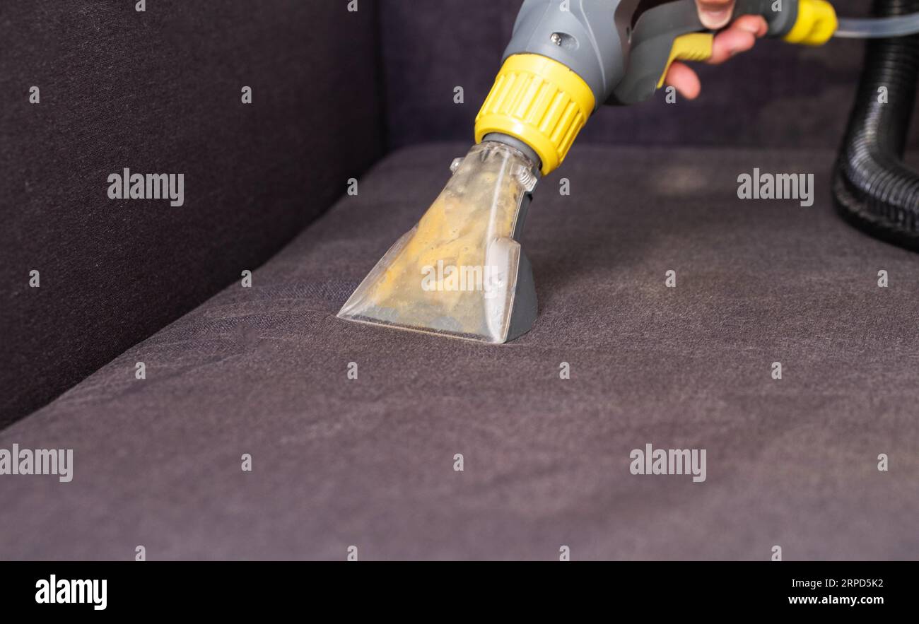Dry cleaning of the black upholstery of the sofa with a special washing ...
